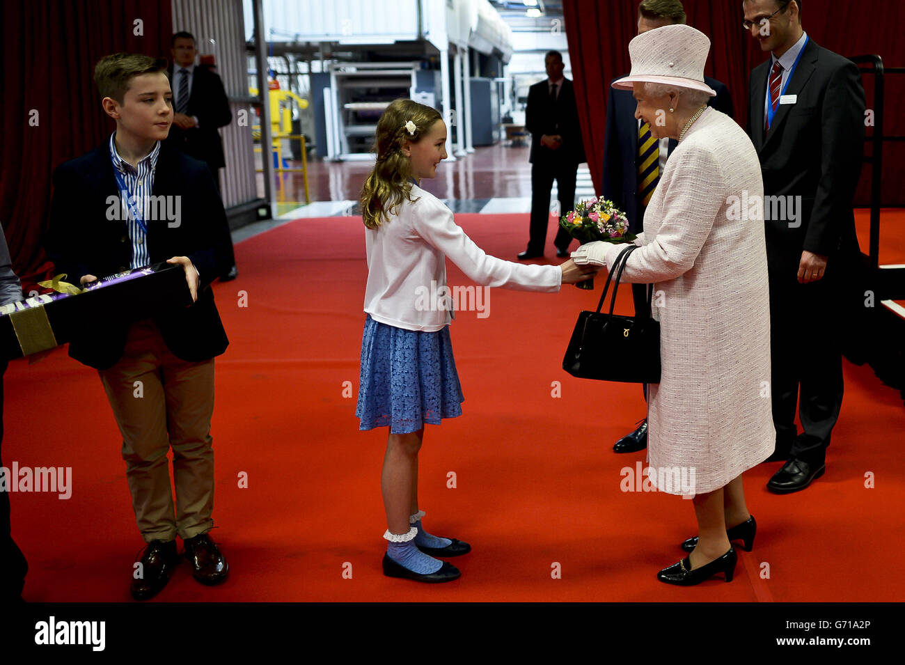 Queen Elizabeth II is given a posie of flowers by Jessica Barrell, aged ...