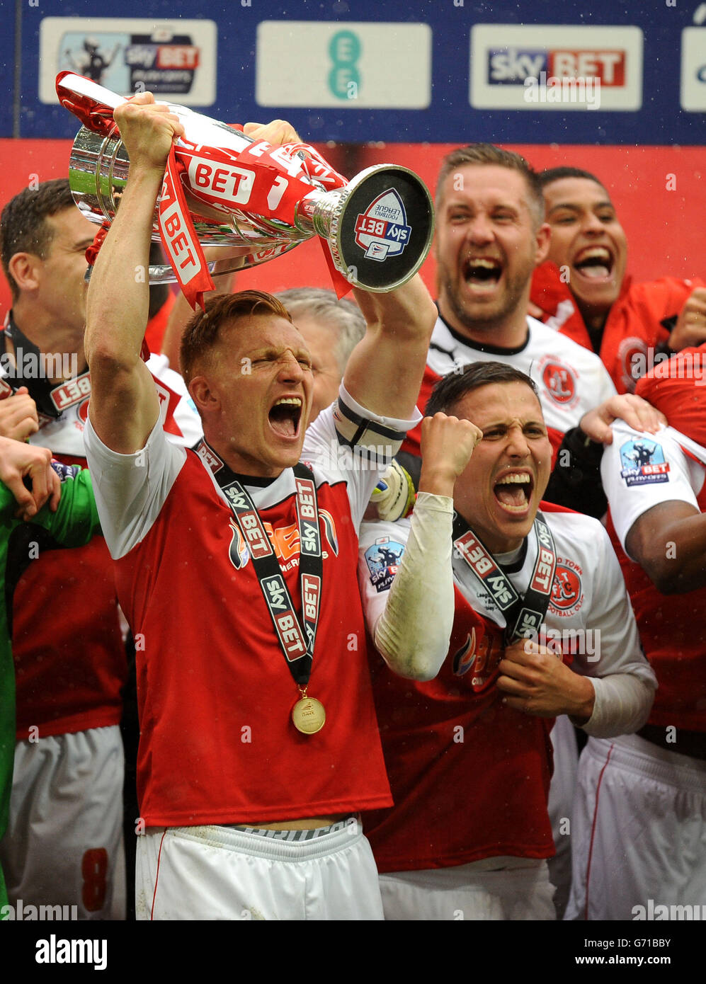 Fleetwood Town captain Mark Roberts celebrates by lifting the trophy ...