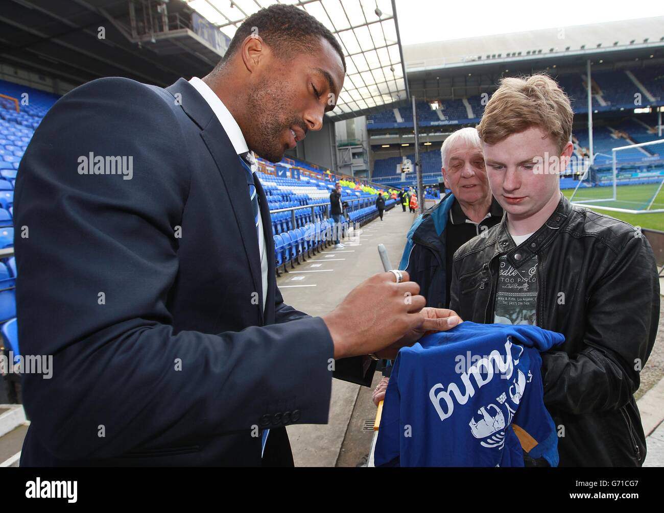 Sylvain Distin, Everton, signs a fan's shirt before the game Stock ...