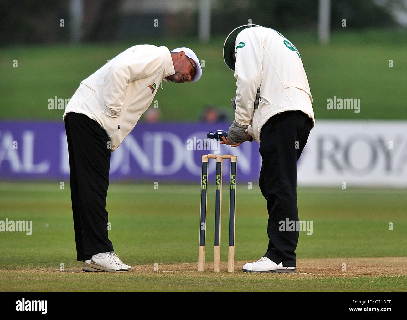 Umpire's Tim Robinson (left) and Neil Mallender check the light before ...