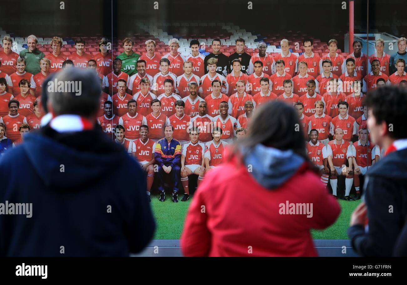 Fans outside the Emirates Stadium look at a Arsenal team group mural on ...