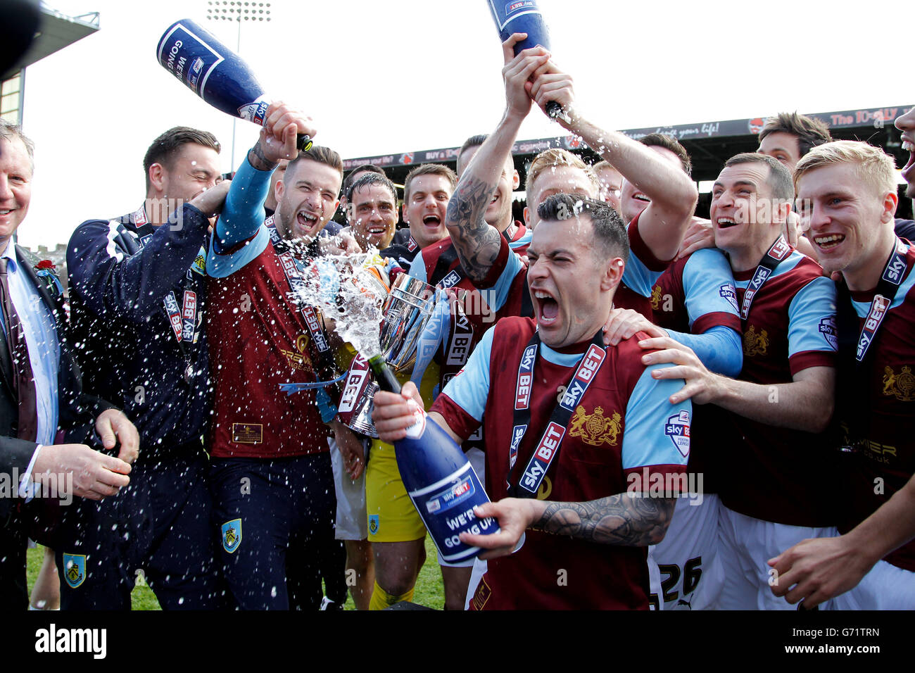 Burnley's players celebrate with champagne after winning promotion and ...