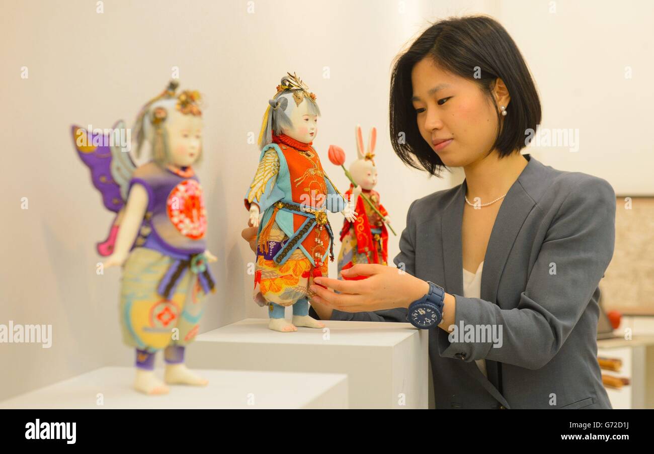 Shoko Aono of the Ippodo Gallery adjusts a set of figures depicting ...