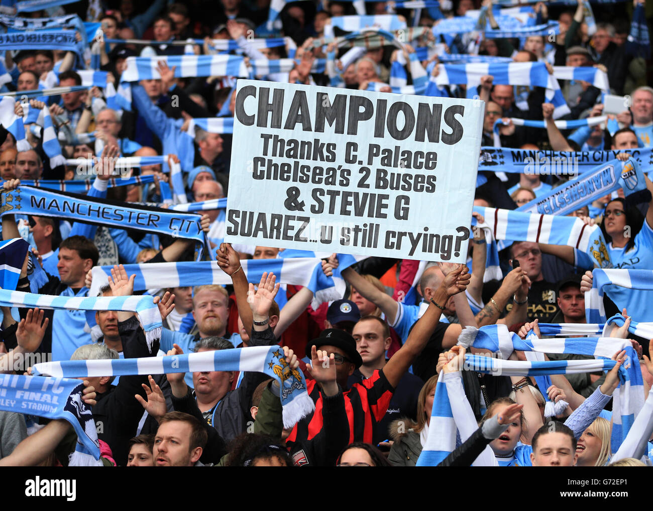 Manchester City's fans hold a banner up in the stands that reads ...