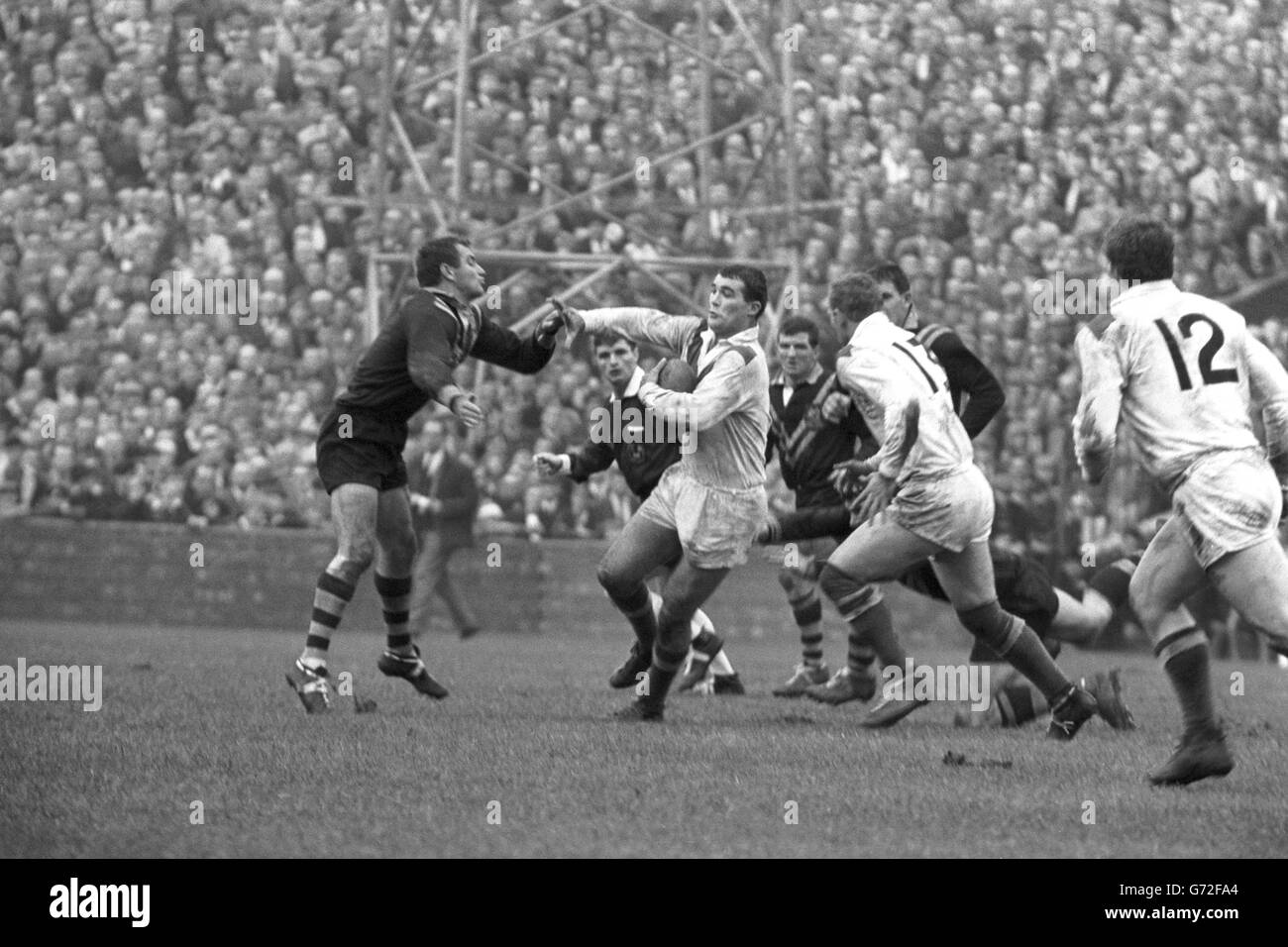 A hand off for Australian captain Reg Gasnier from William Holliday ...