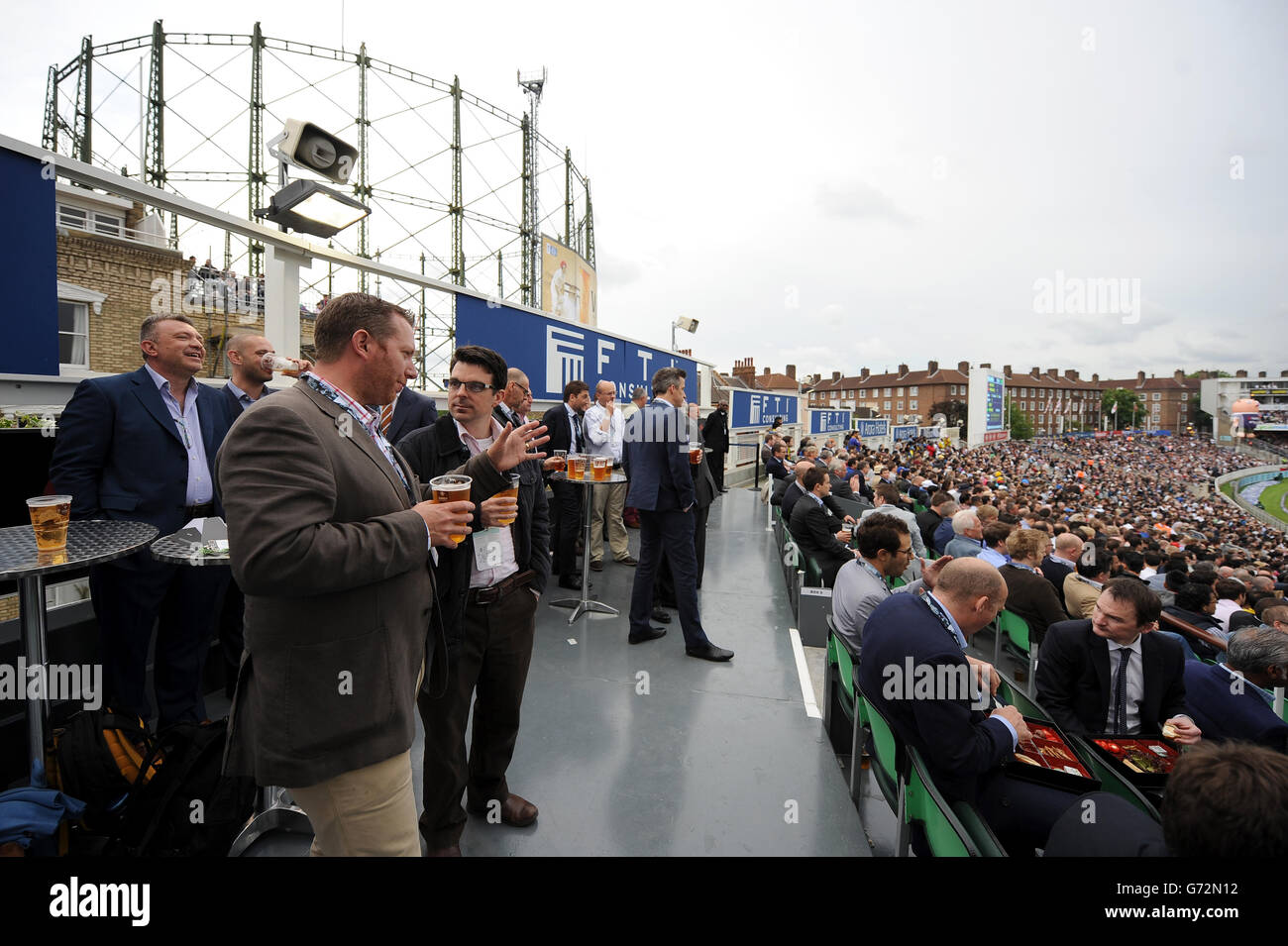 Spectators eat lunch and have a drink whilst watching the cricket Stock ...