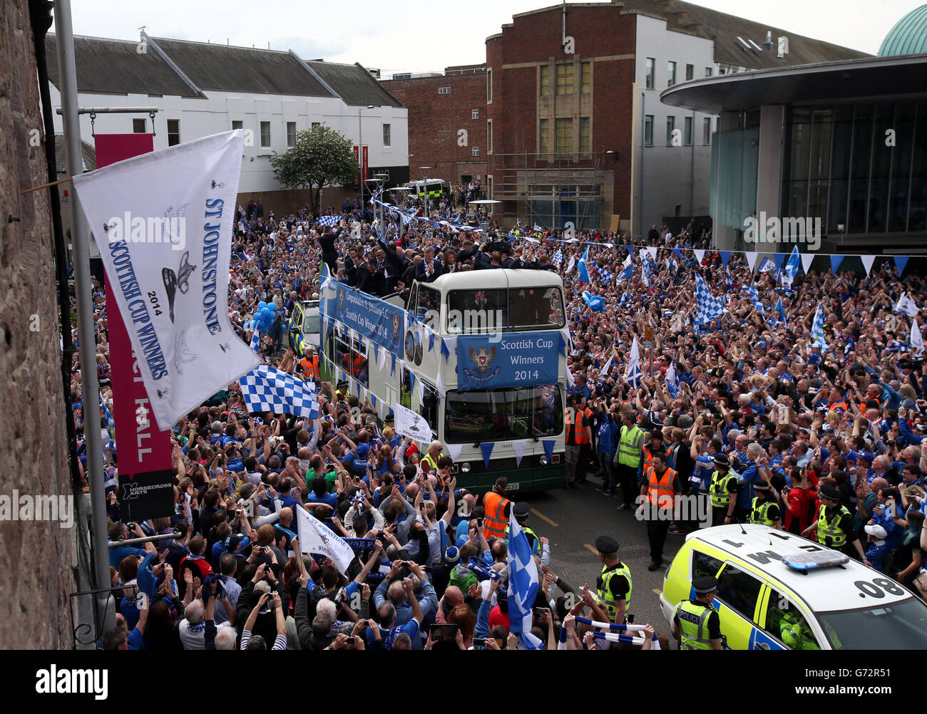The St Johnstone team make their way through the crowds on an open top ...