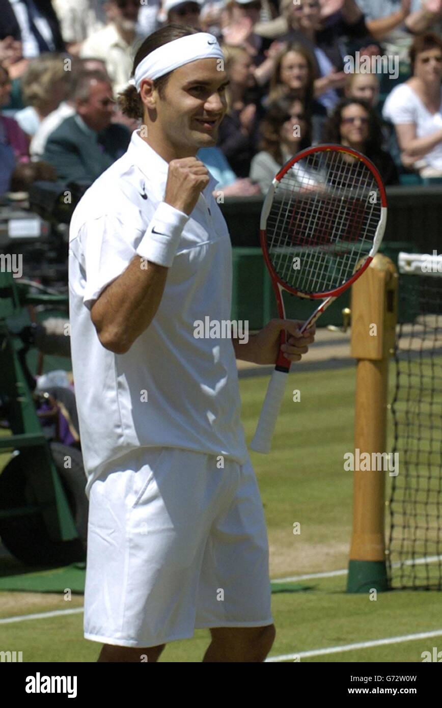 Defending champion Roger Federer from Switzerland raises his racquet ...