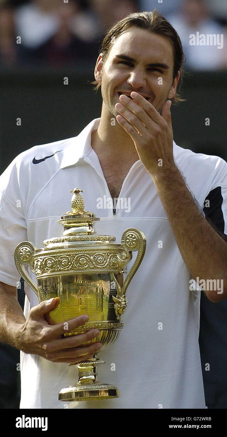 Roger Federer from Switzerland holds the trophy after defeating Andy ...