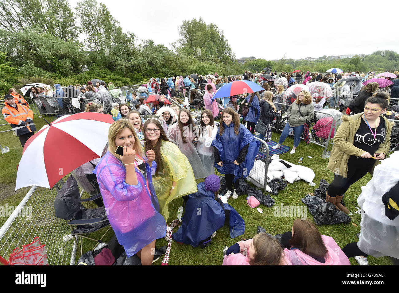 Fans of One Direction wait outside in the rain ahead of their concert ...