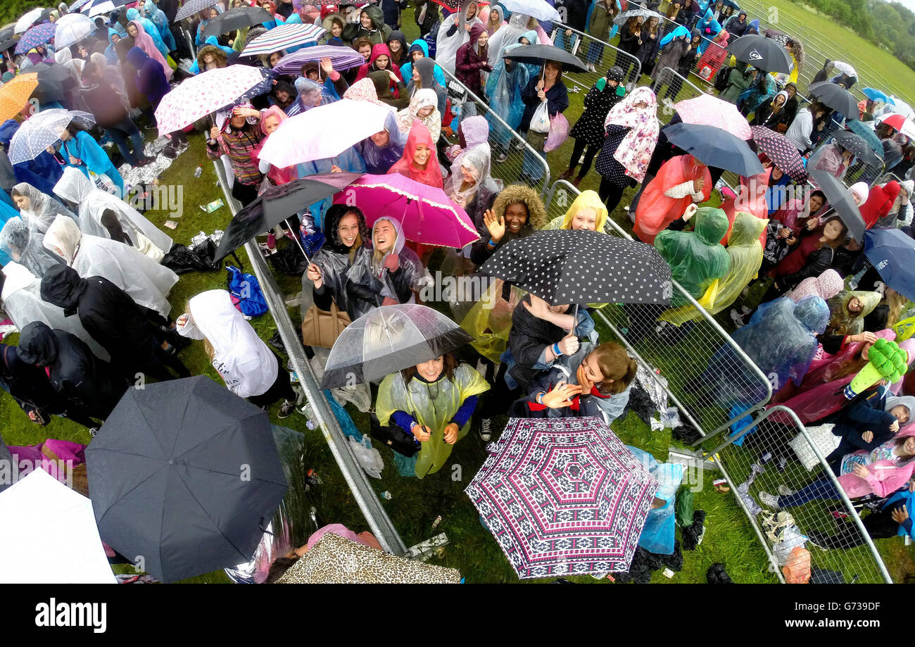 Fans of One Direction queue outside in the rain ahead of their concert ...