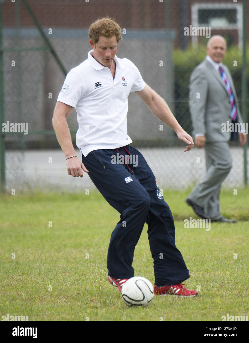 Prince Harry enjoys a game of football with young children at the ...