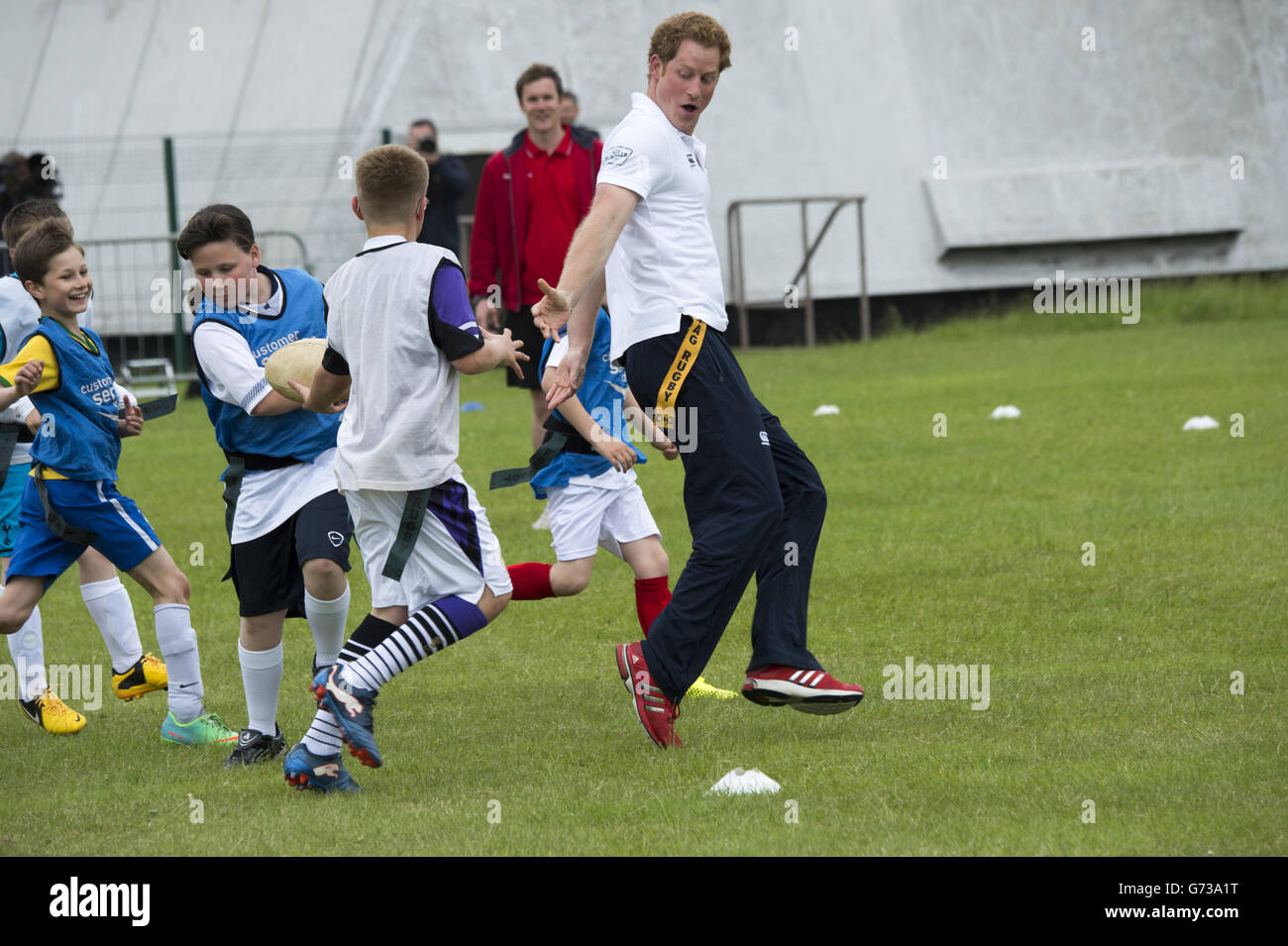 Prince Harry enjoys a game of touch Rugby with young children at the ...