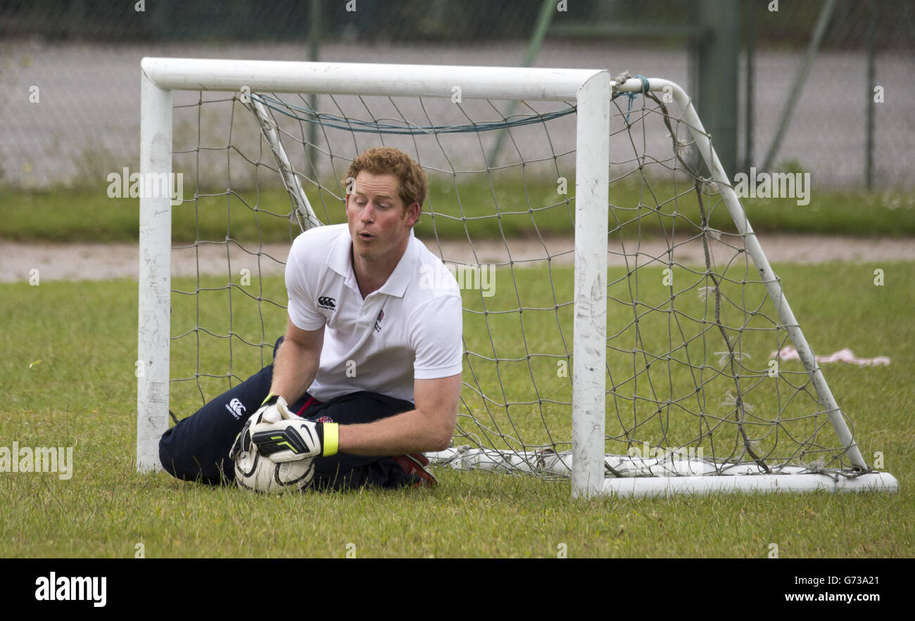 Prince Harry enjoys a game of football with young children at the ...