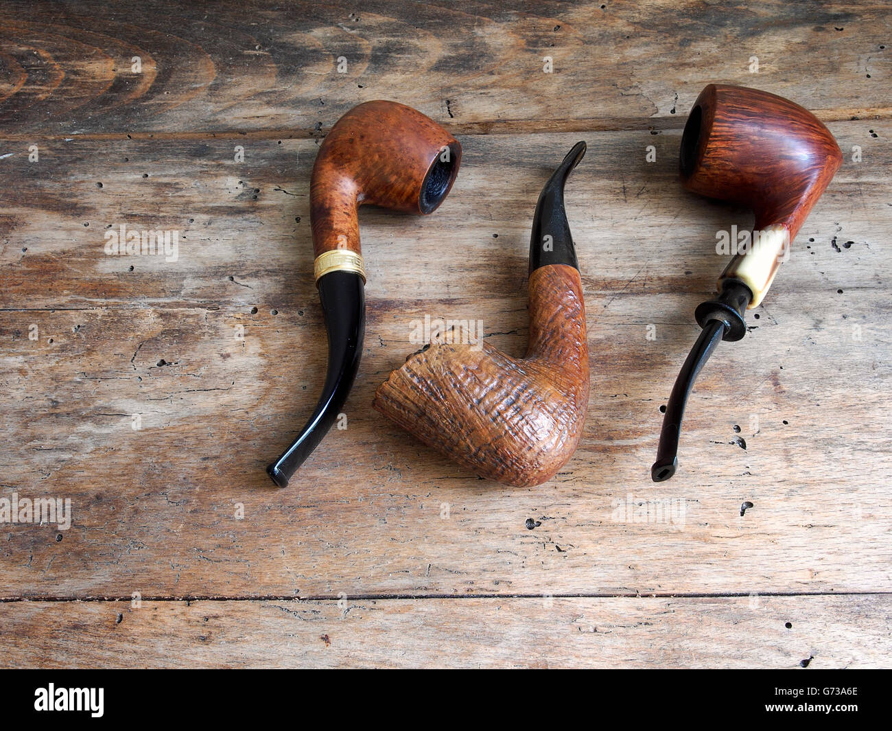 Three wooden, curved and handmade, pipes on a table Stock Photo - Alamy