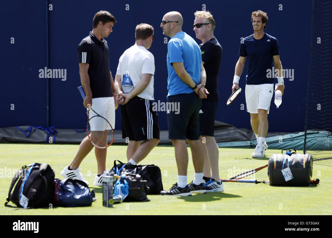 Andy Murray (right) walks past members of his coaching team while he ...