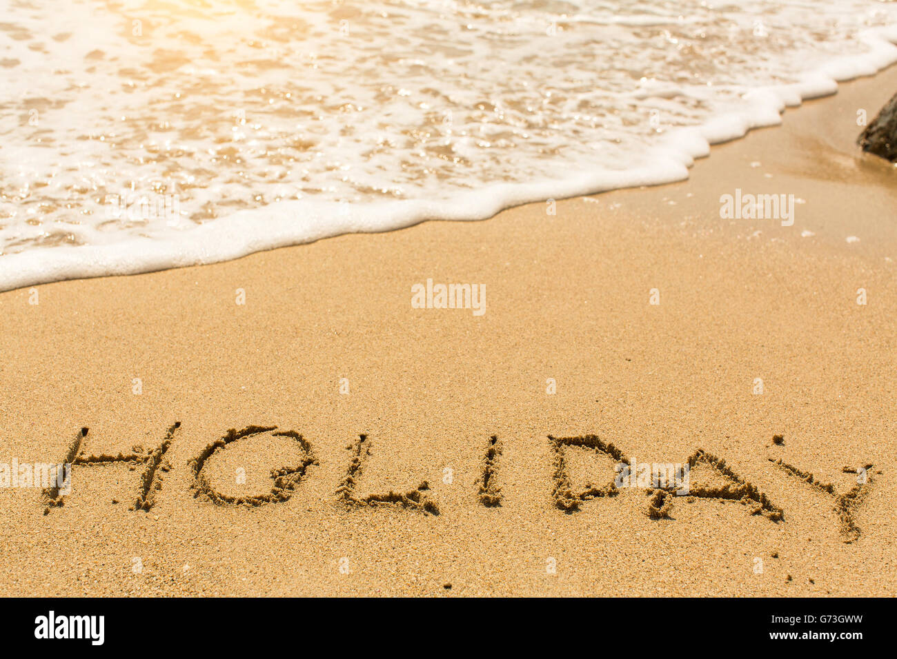 Holiday - word drawn on the sand beach with the soft wave Stock Photo ...