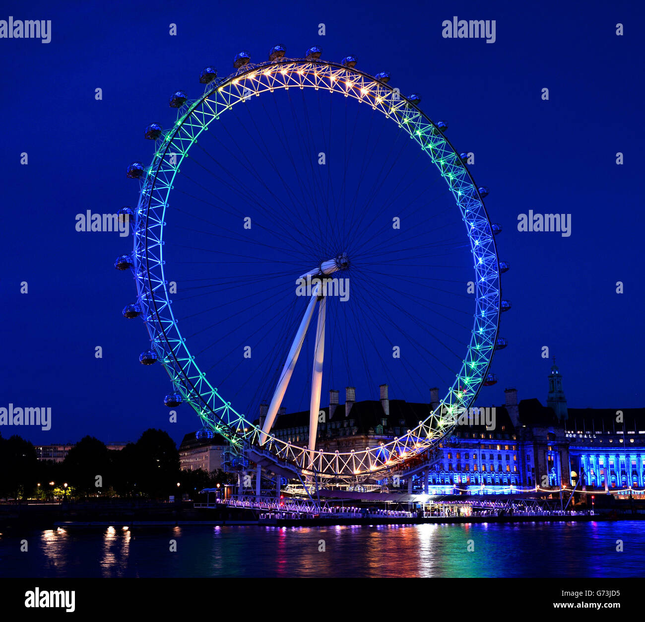 the EDF London Eye as the wheel lights turn yellow, blue and green to ...