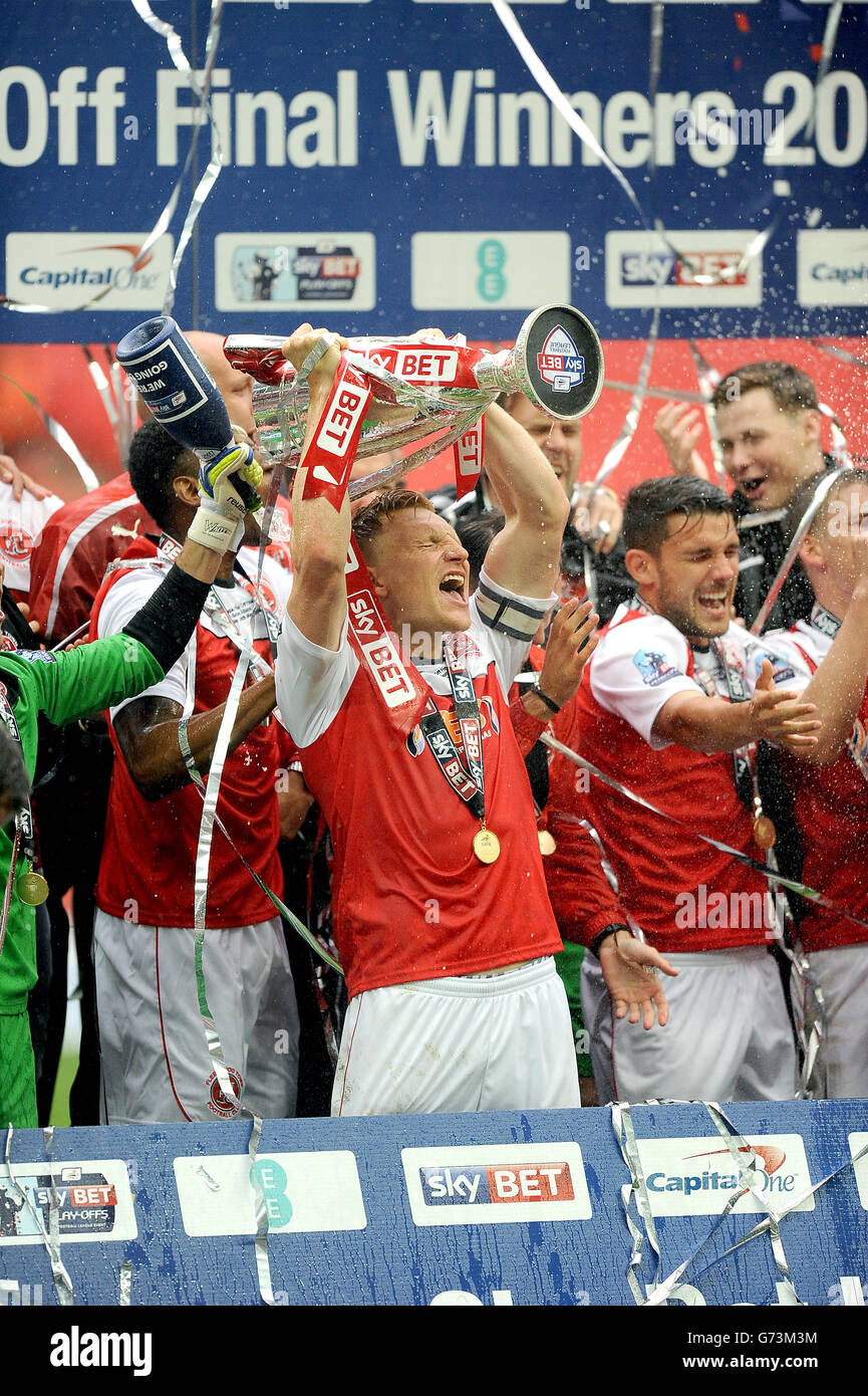 Fleetwood Town captain Mark Roberts celebrates by lifting the trophy ...