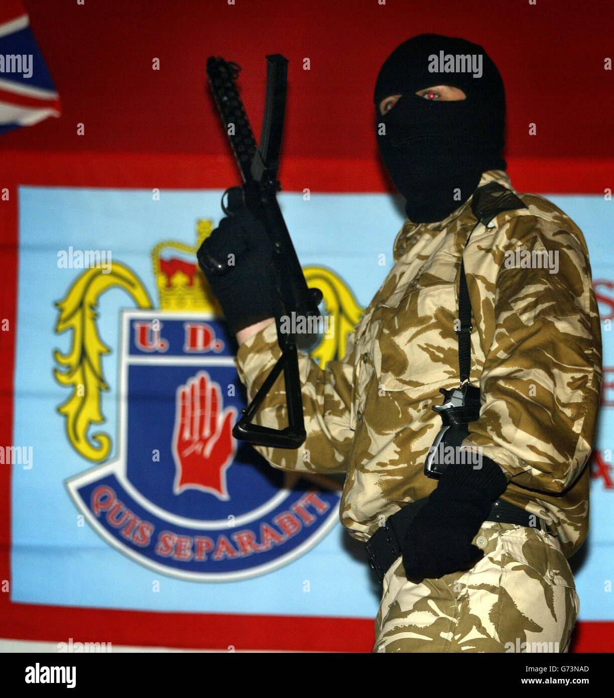 A masked member of the Ulster Freedom Fighters (UFF), displays a ...