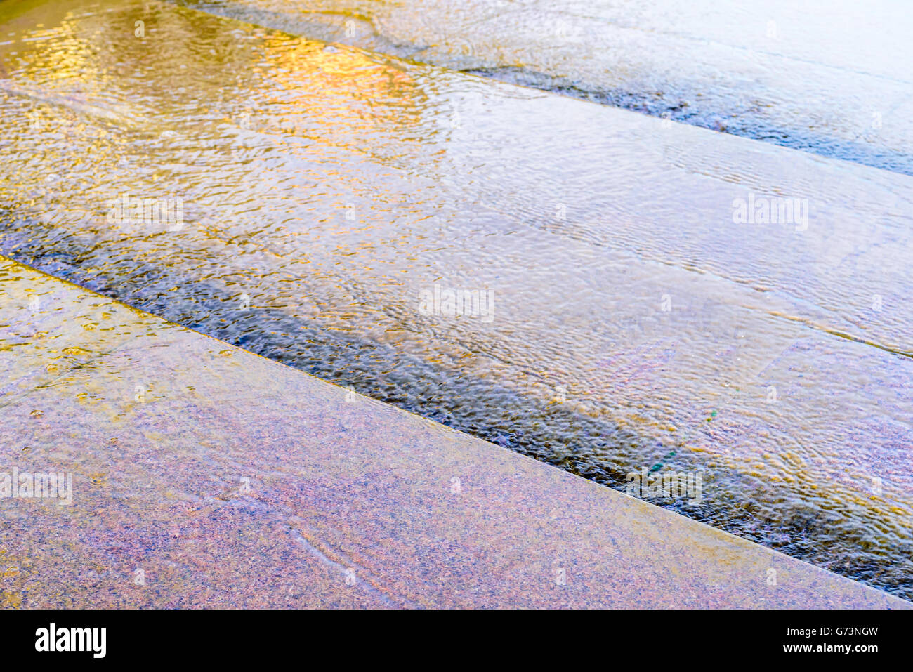 Water flowing over granite slab creating small ripples along the way ...