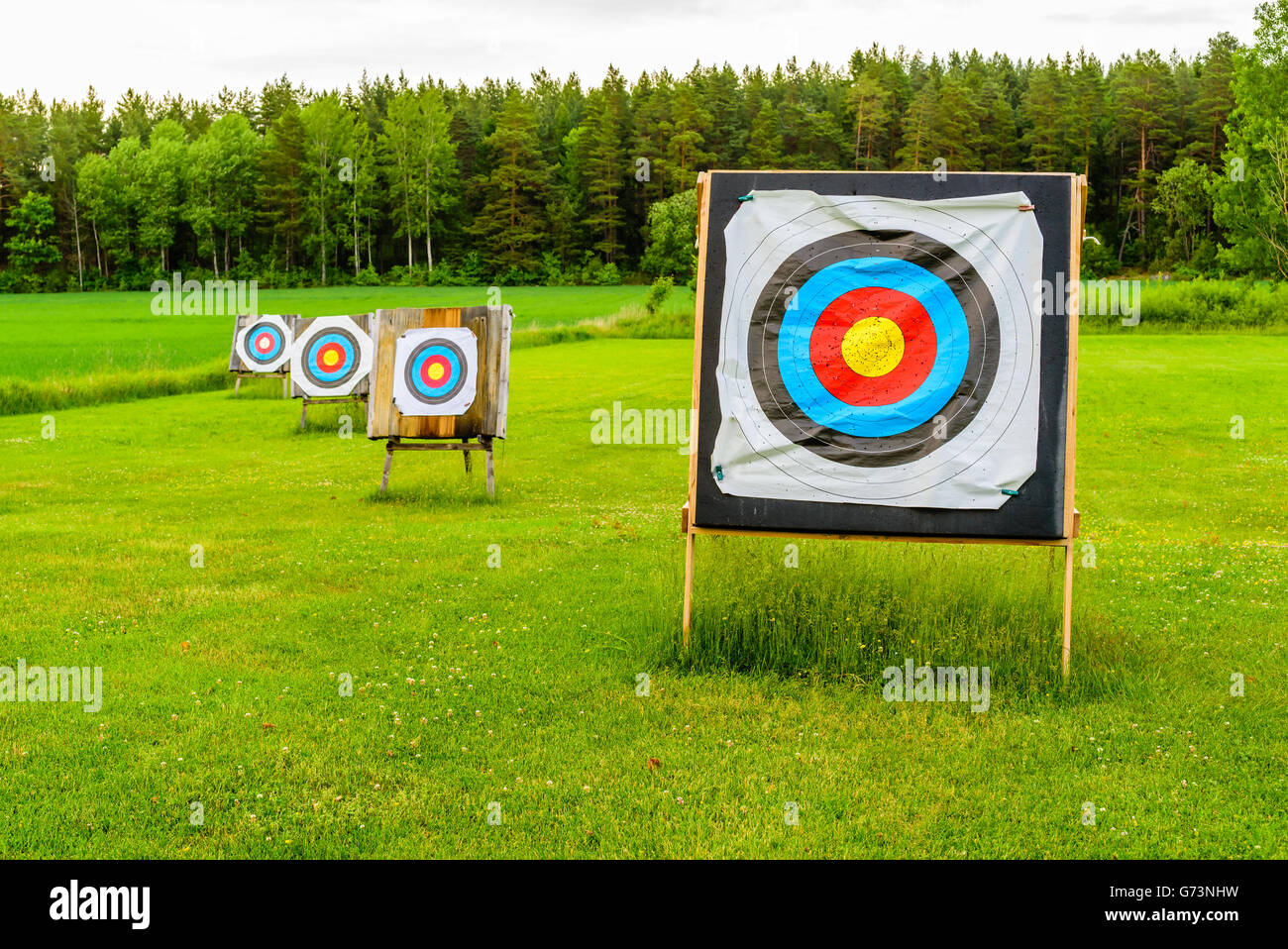 Outdoor archery targets on grass field surrounded by forest in the ...