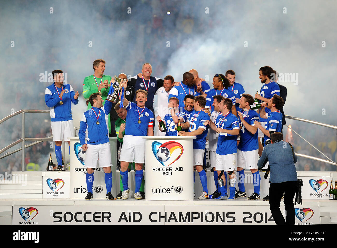 Rest of the World's Michael Sheen and Gordon Ramsay lift the trophy ...