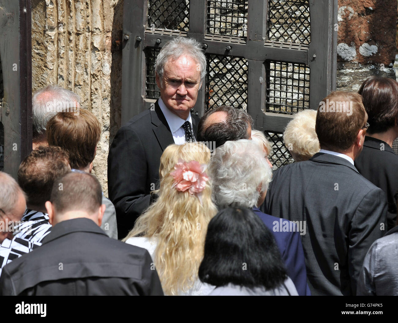 Nigel Planer (centre) stands with mourners as he leaves St George's ...