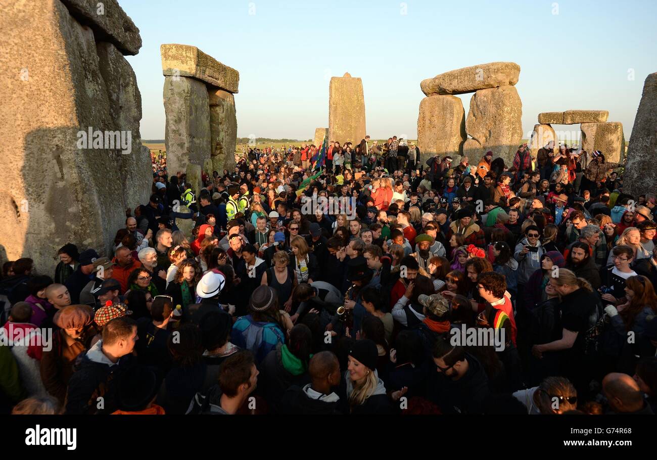 Summer Solstice at Stonehenge. Crowds gather at dawn amongst the stones ...