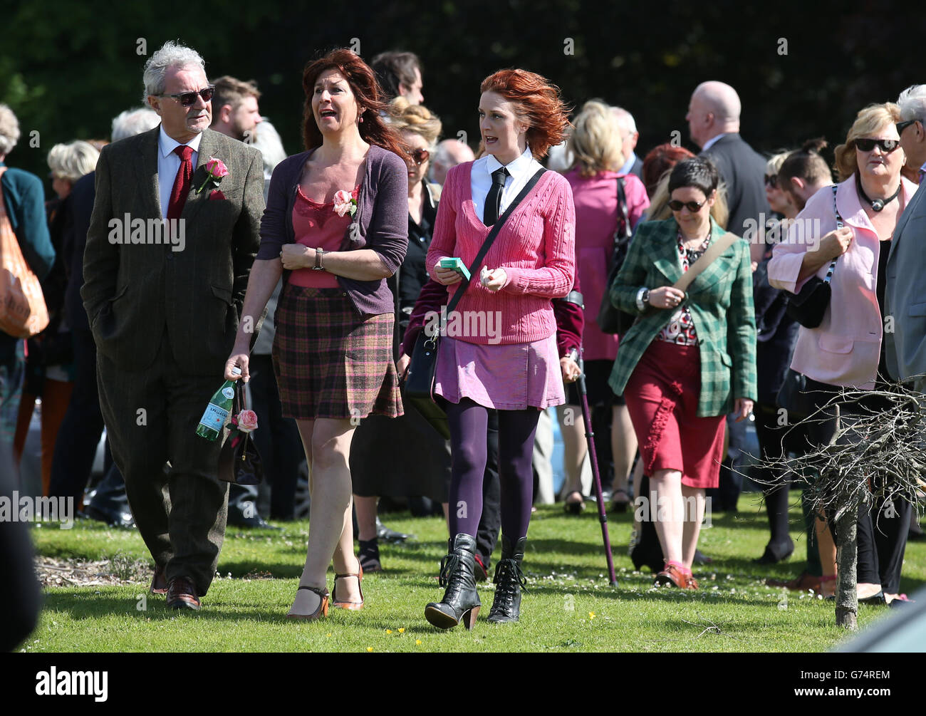 Mourners arrive in bright colours to pay their respects at the funeral ...