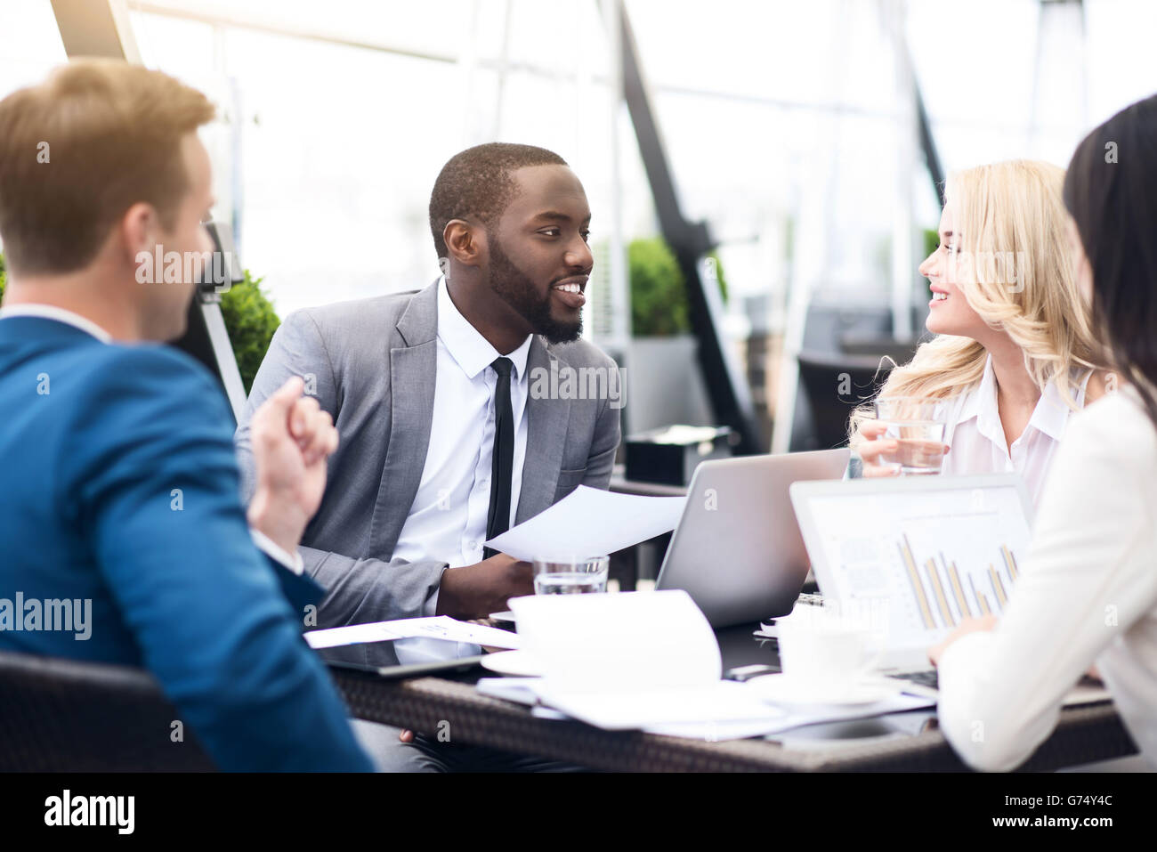 Pleasant involved colleagues discussing project Stock Photo - Alamy