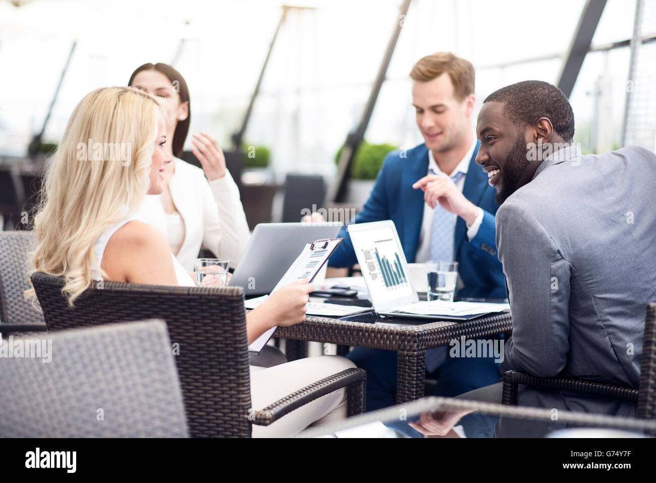 Nice positive colleagues talking Stock Photo - Alamy