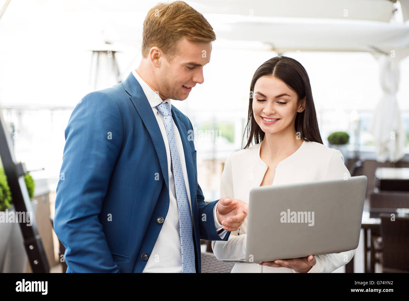 Cheerful colleagues using laptop Stock Photo - Alamy