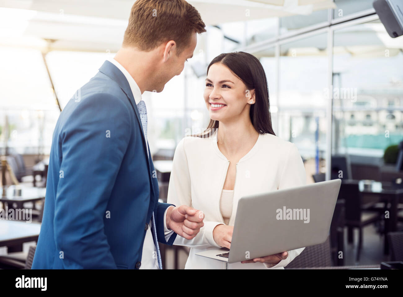 Cheerful smiling colleagues talking Stock Photo - Alamy