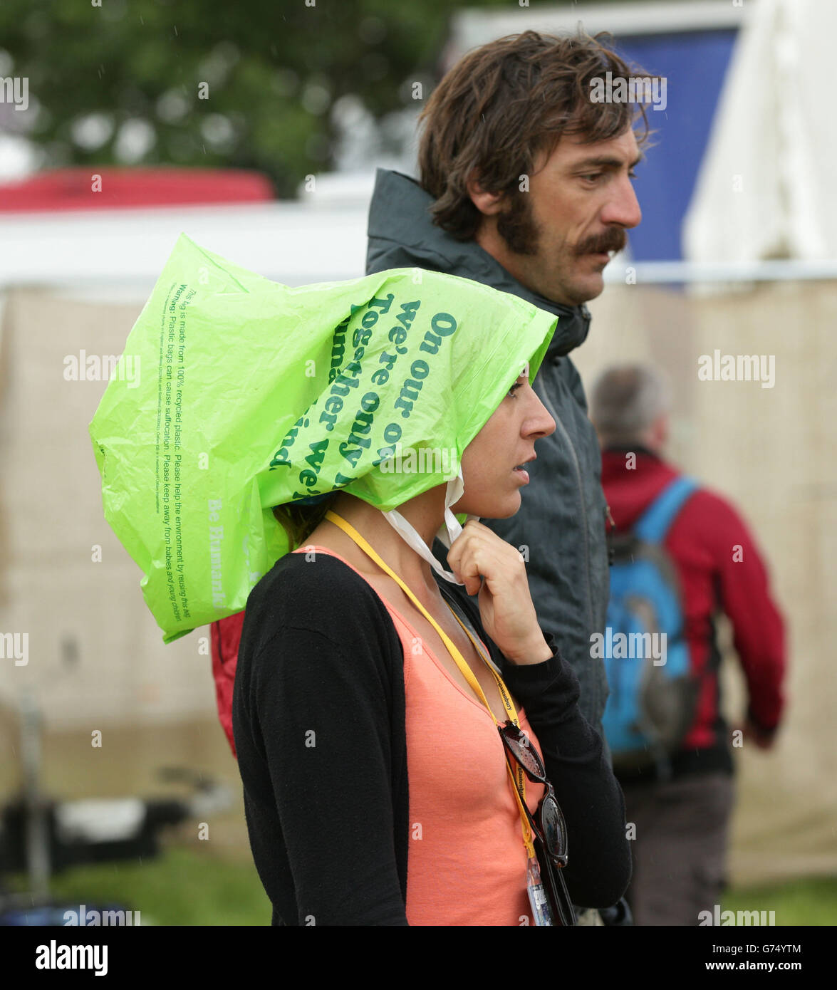 Festival Goers During A Rain Shower At The Glastonbury Festival At