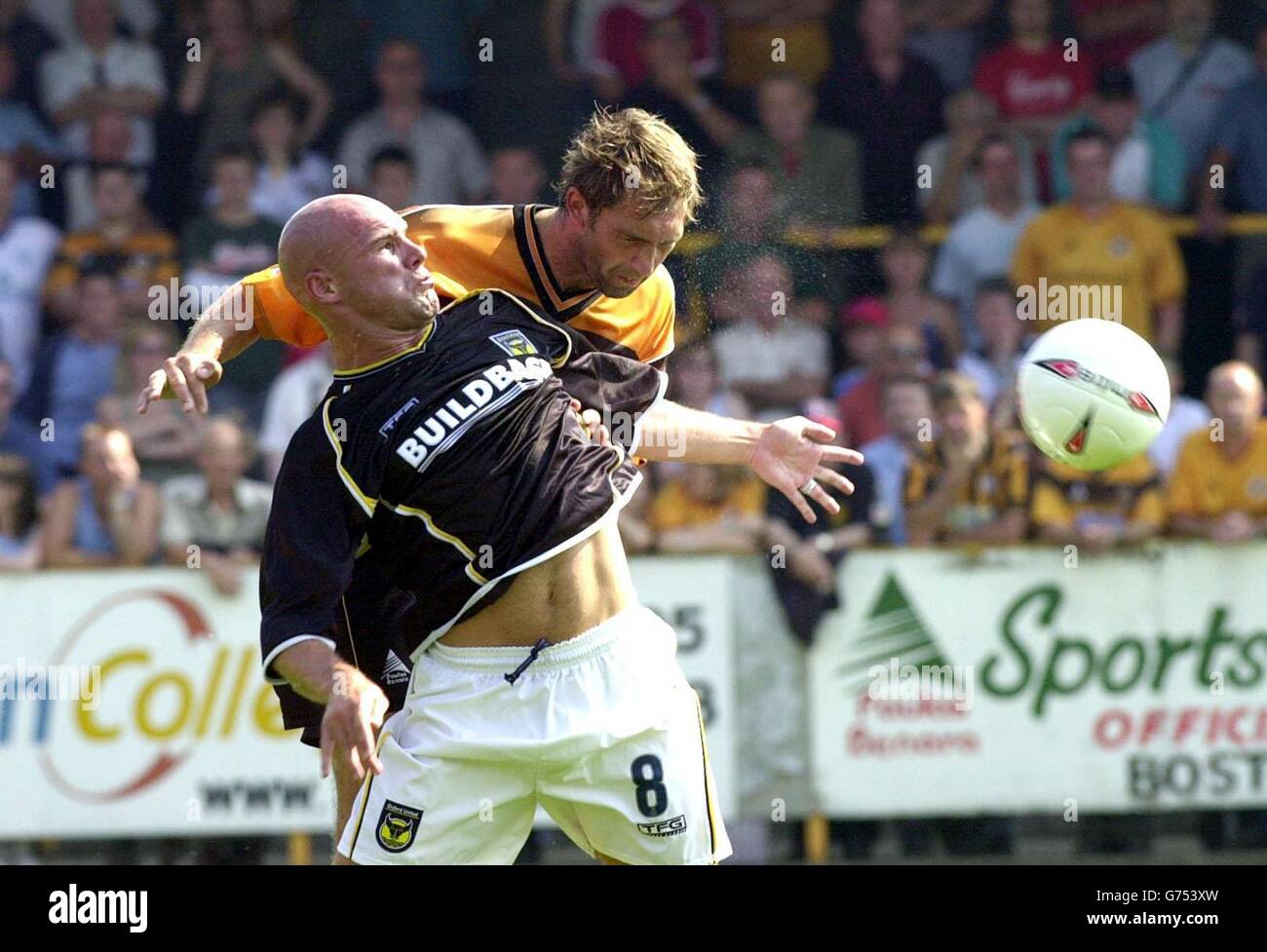 Oxford 's Tommy Mooney (number 8) is beaten to the ball Boston United's ...