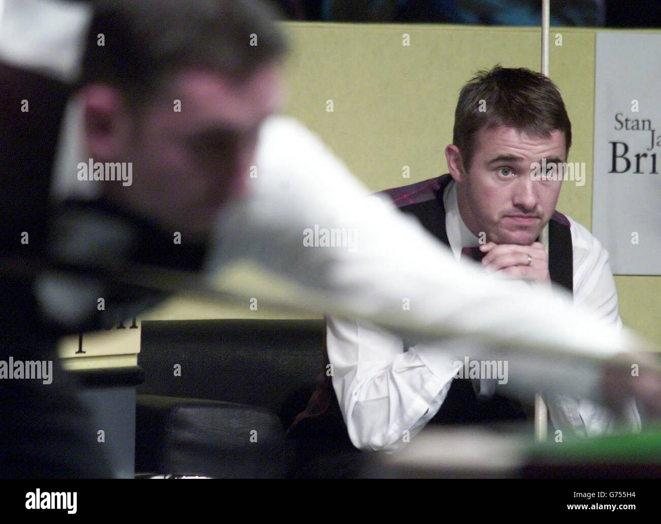 A dejected Stephen Hendry sits in his seat as Anthony Davies beats him ...