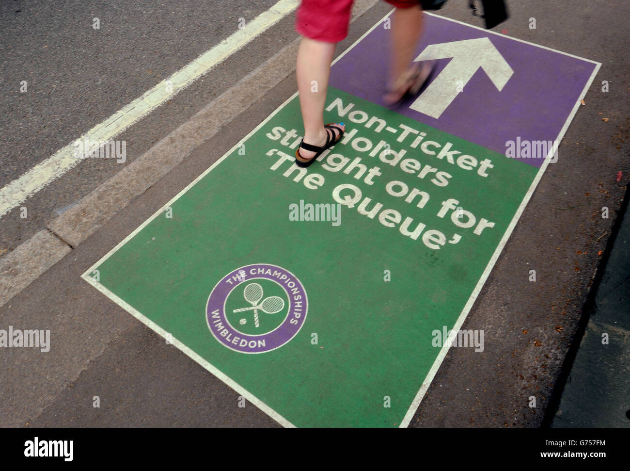 A fan walks over a sign during day two of the Wimbledon Championships ...
