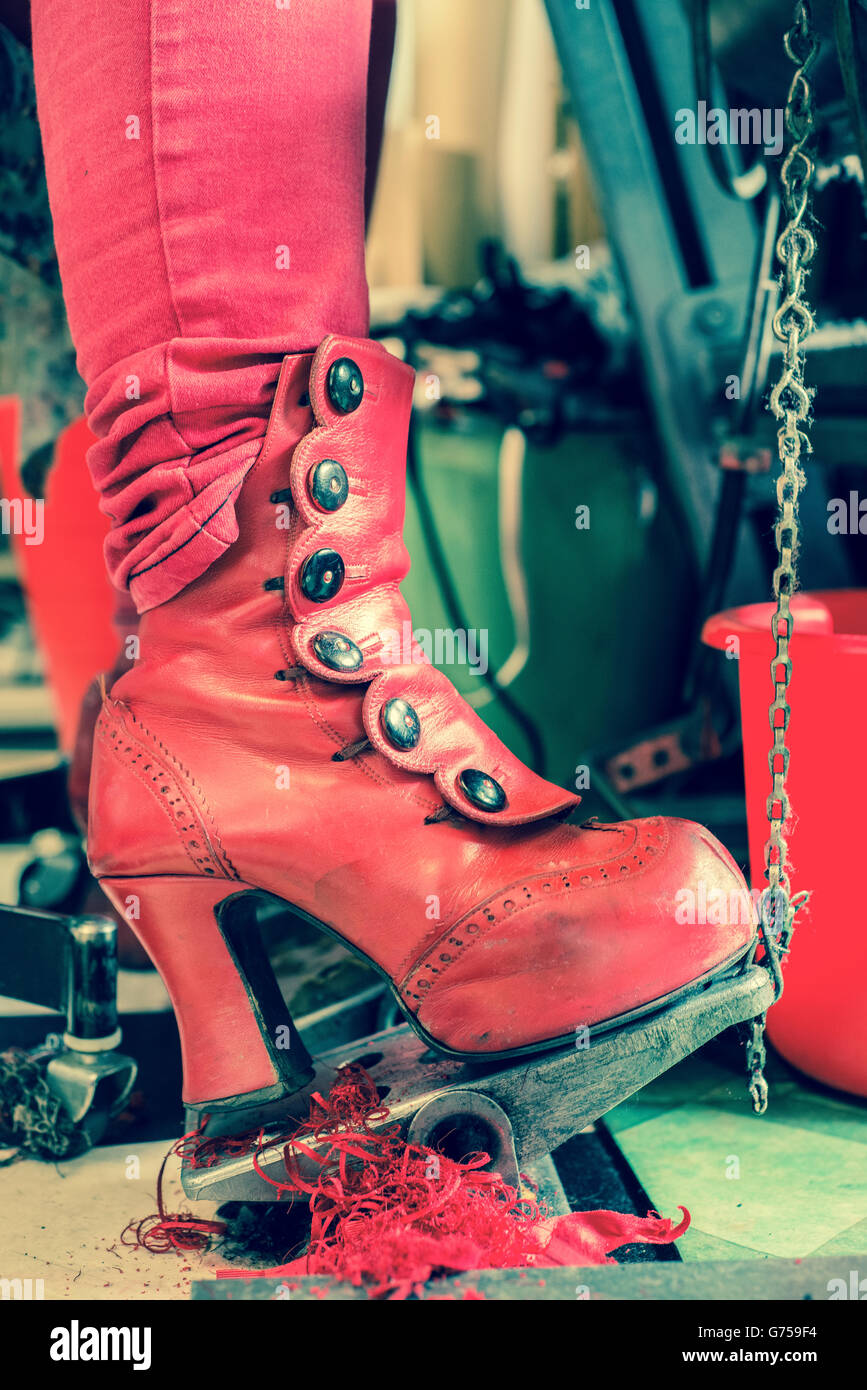 Red boot on sewing machine pedal Stock Photo - Alamy
