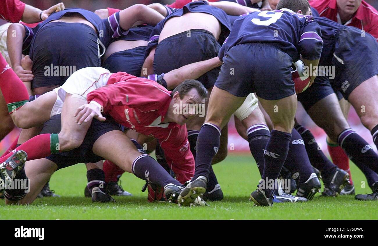 Wales' scrum half Rob Howley stretches to stop Scotland's Bryan Redpath ...