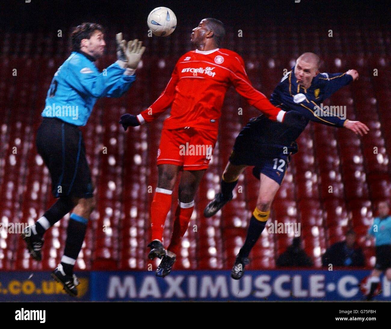 Wimbledon goalkeeper Ian Feuer and Trond Anderson (R) pressurise ...