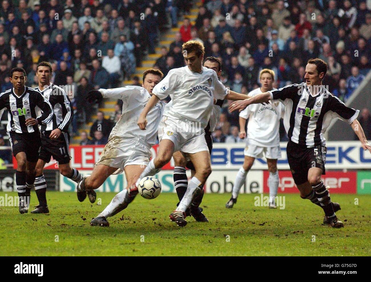 Jonathan Woodgate (centre) and Mark Viduka (centre, behind) of Leeds ...