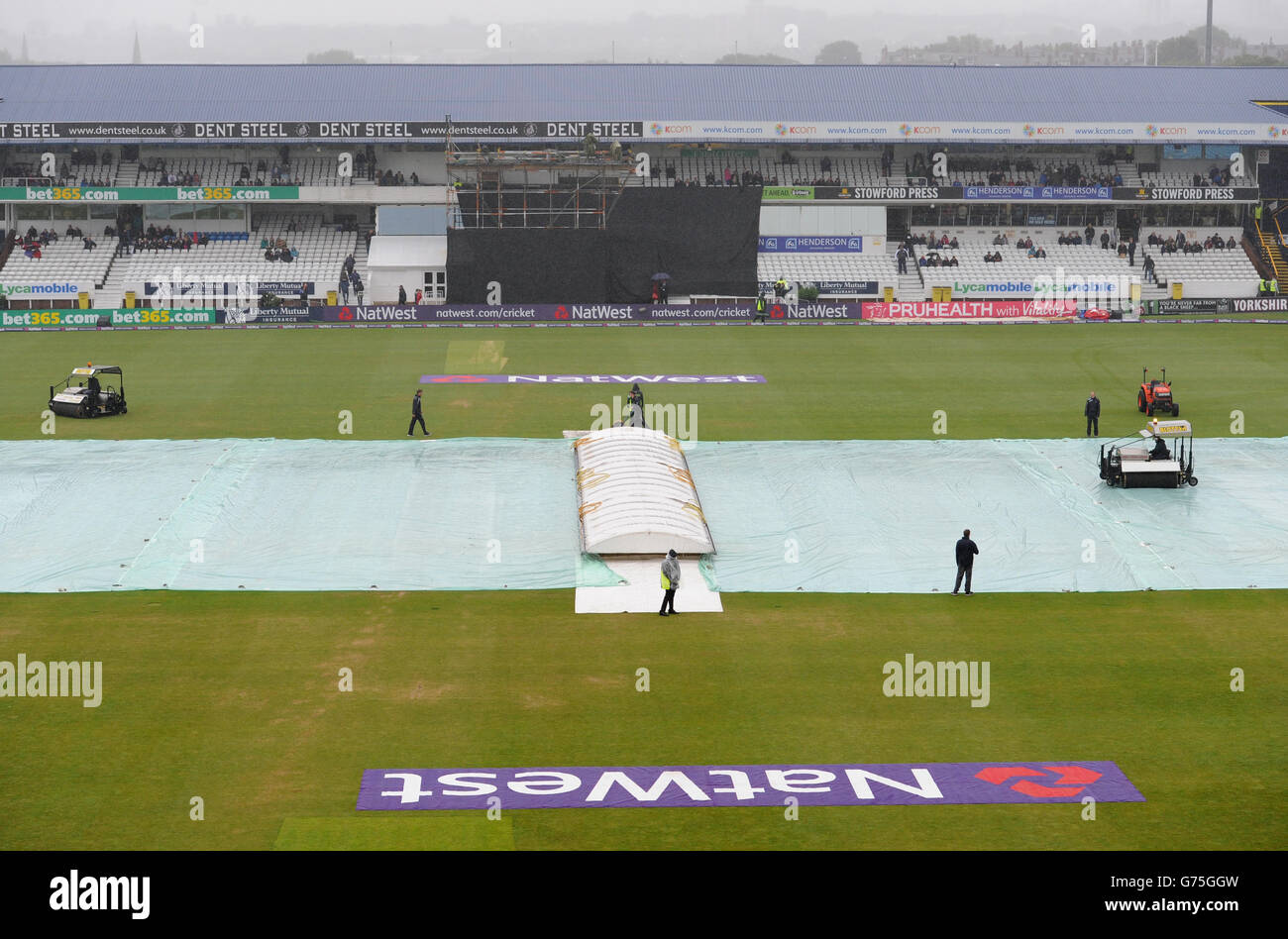 A general view showing the Headingley pitch covered as rain falls ...