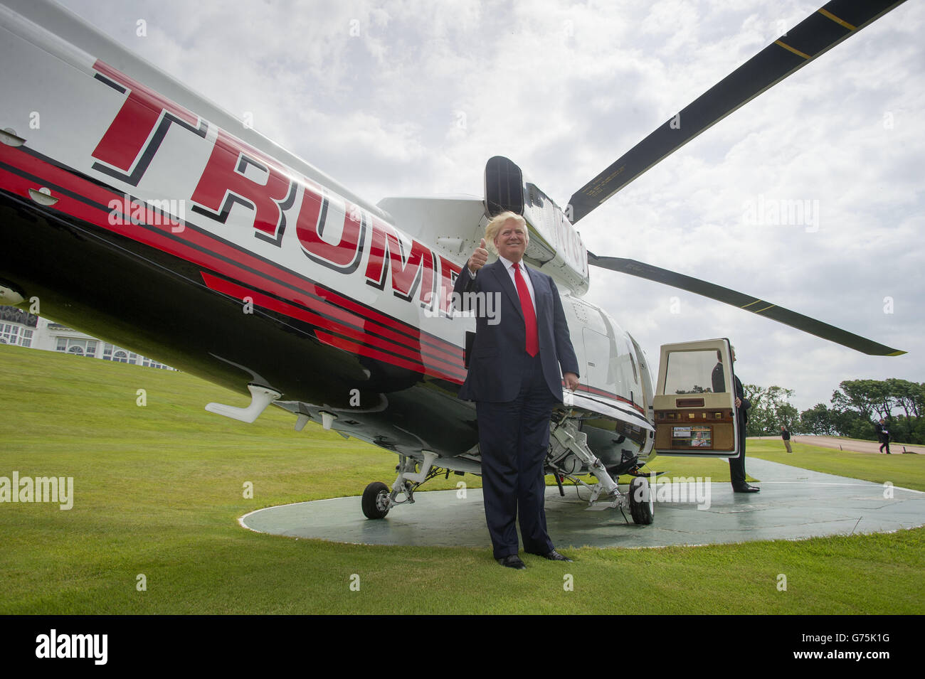 Donald Trump poses beside his helicopter prior to taking a flight over ...