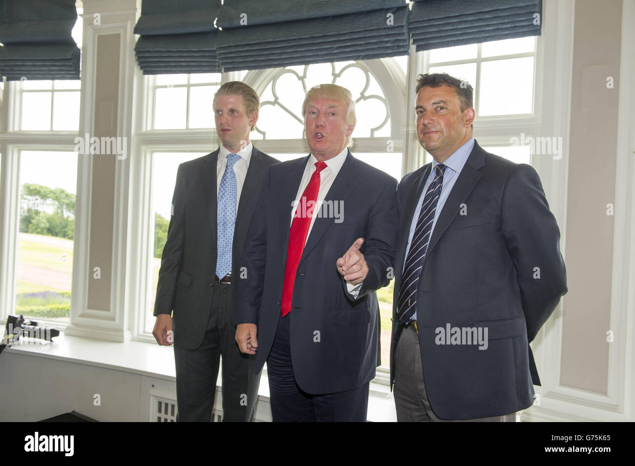 Donald Trump is flanked by his son Eric (L) and golf architecht Martin ...