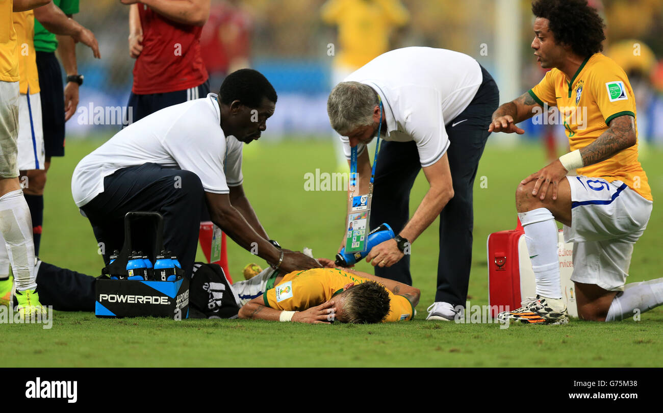 Brazil's Neymar receives treatment for a back injury on the pitch ...
