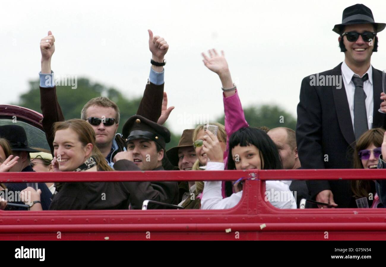 Race-goers in fancy dress arriving on an open-top bus at Epsom Downs ...