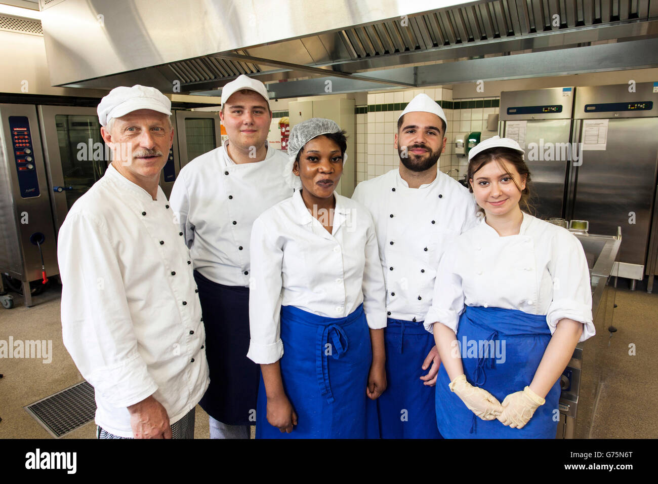 Chef and his team in the kitchen Stock Photo - Alamy
