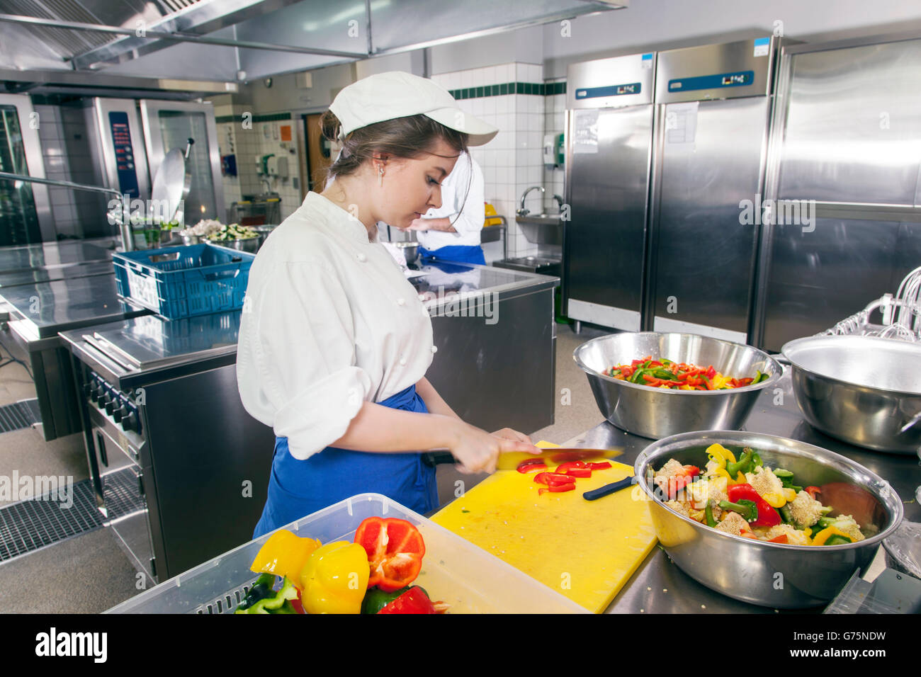 Apprentice cook cut paprika for lunch Stock Photo - Alamy