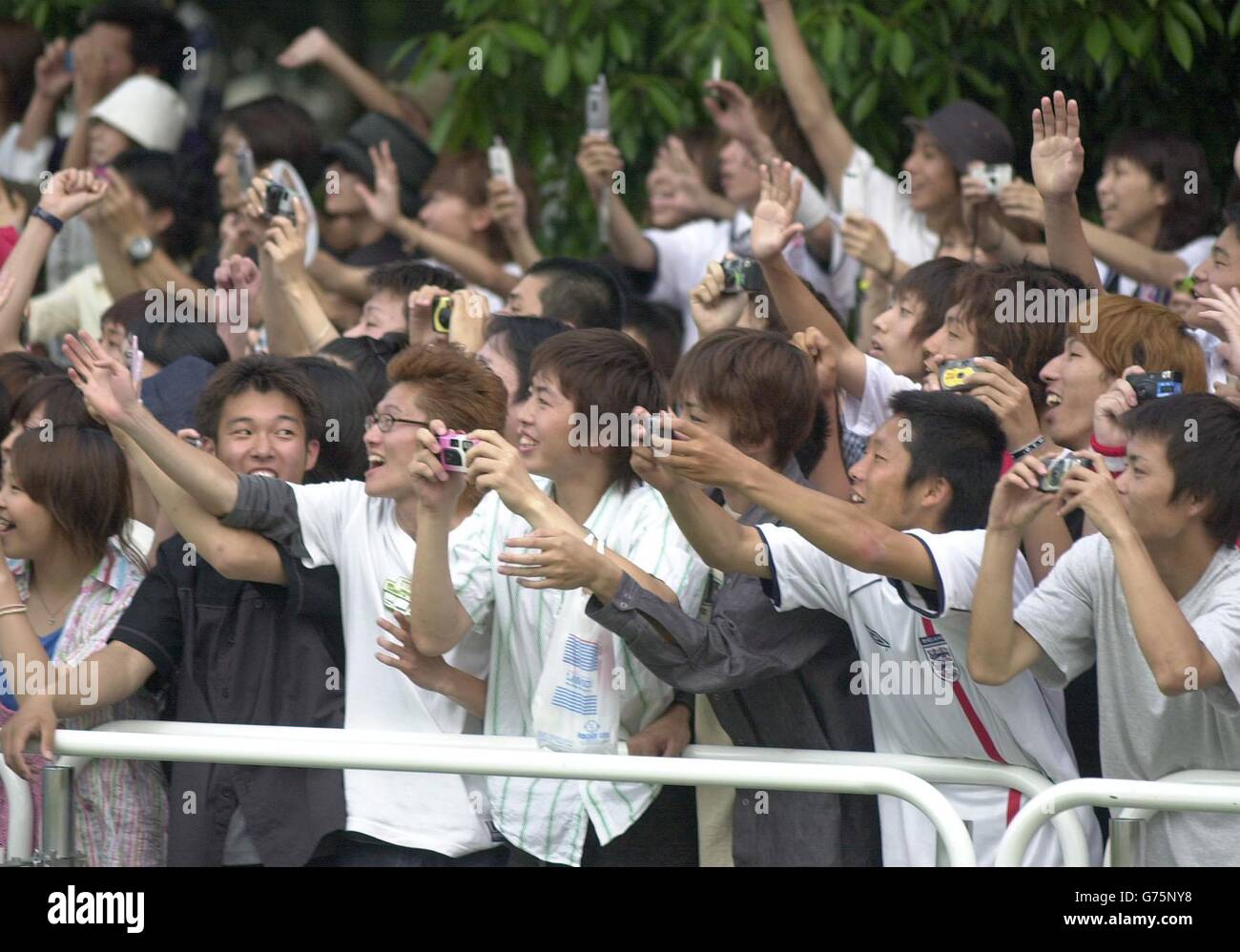 Japanese fans wave at the England team bus Stock Photo - Alamy